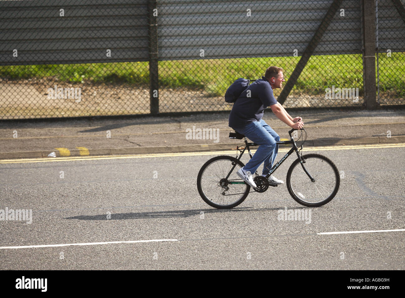 Cyclist speeding down road in Heathrow London uk Stock Photo - Alamy