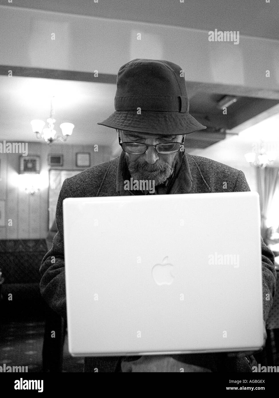 Old man in pub using Apple Mac laptop Stock Photo - Alamy