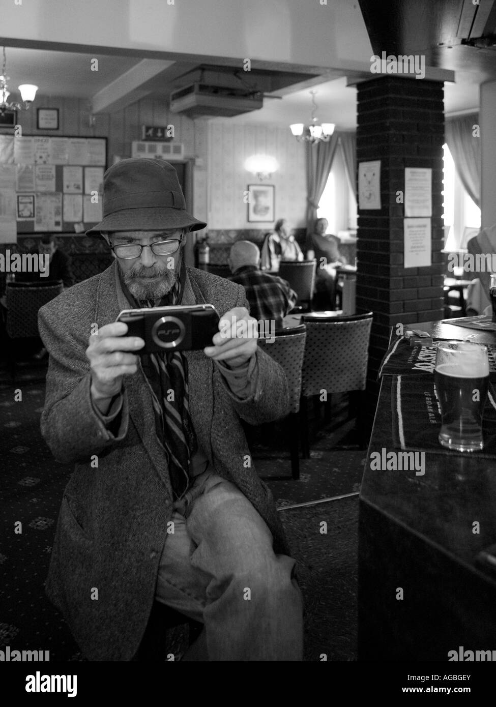 Old man in pub using Sony PSP playstation Stock Photo - Alamy