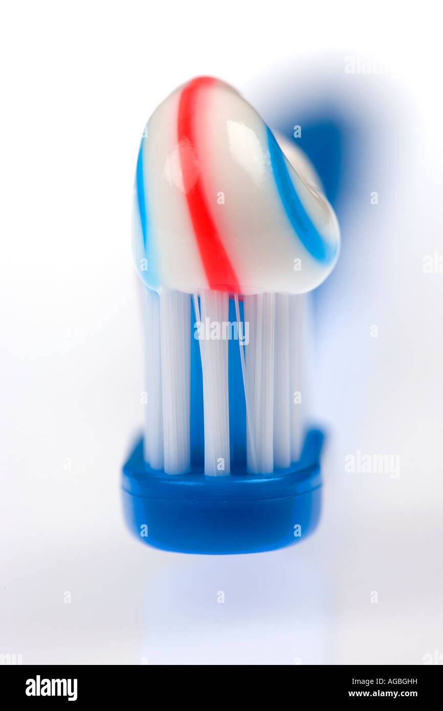 Close up of stripy toothpaste on blue toothbrush Stock Photo - Alamy