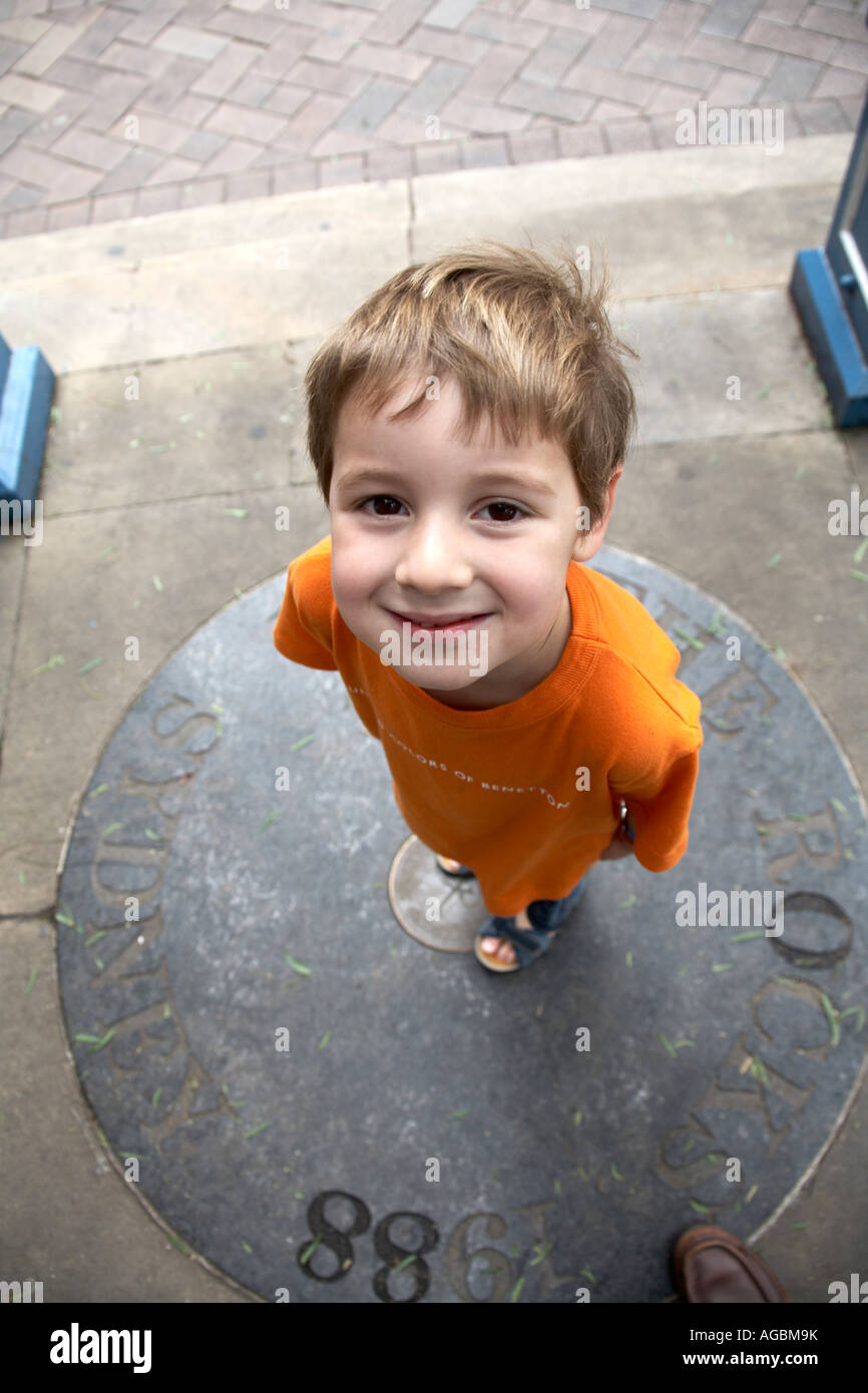 Young boy child from above smiling on first fleet memorial in Sydney ...