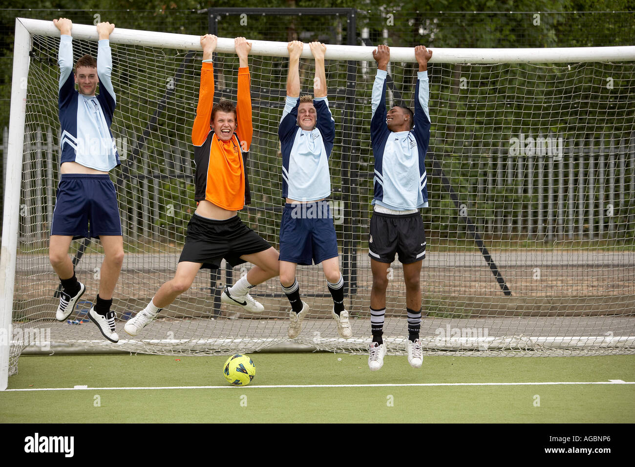 Football players hang from the cross bar Stock Photo - Alamy