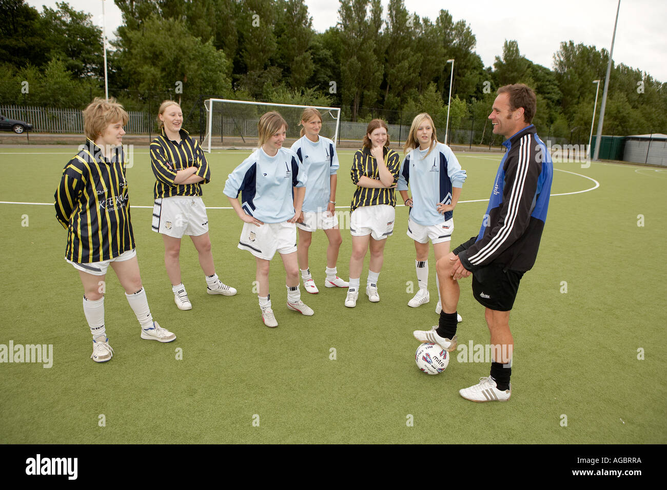 Girls football team watch their coach during training session Stock ...