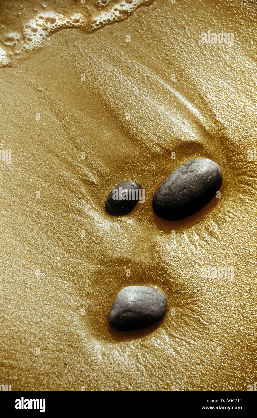Pebbles in sand on beach Stock Photo - Alamy