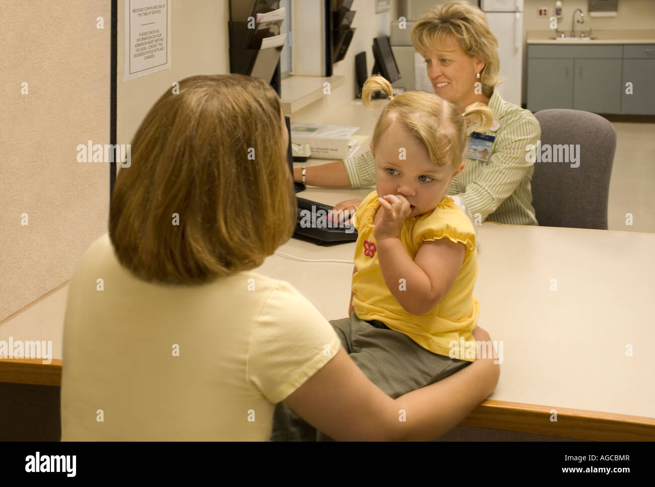 Toddler and young mother at hospital reception counter Stock Photo - Alamy