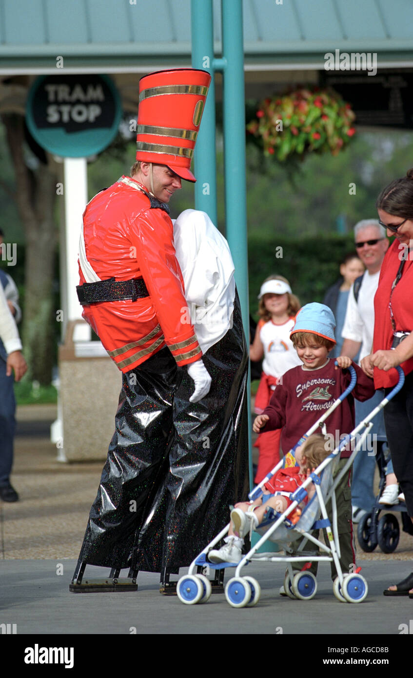 Children pose with a man on stilts at SeaWorld in Orlando Florida USA ...