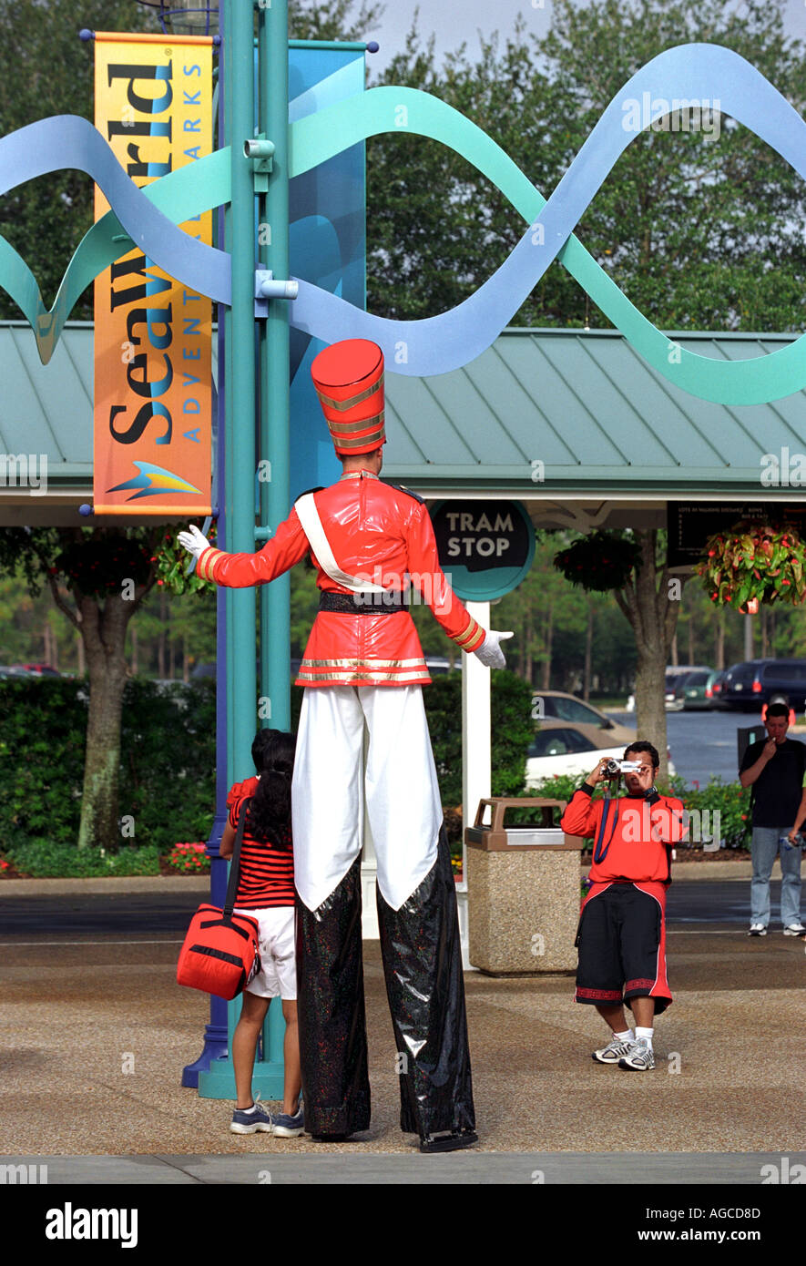 Children pose with a man on stilts at SeaWorld in Orlando Florida USA ...