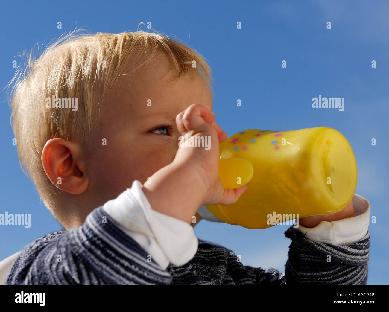 Baby boy drinking tea from bottle Stock Photo - Alamy