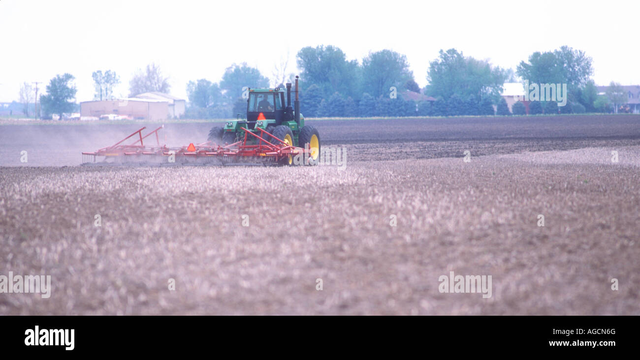 A John Deere tractor pulling a tiller in preparation for spring ...