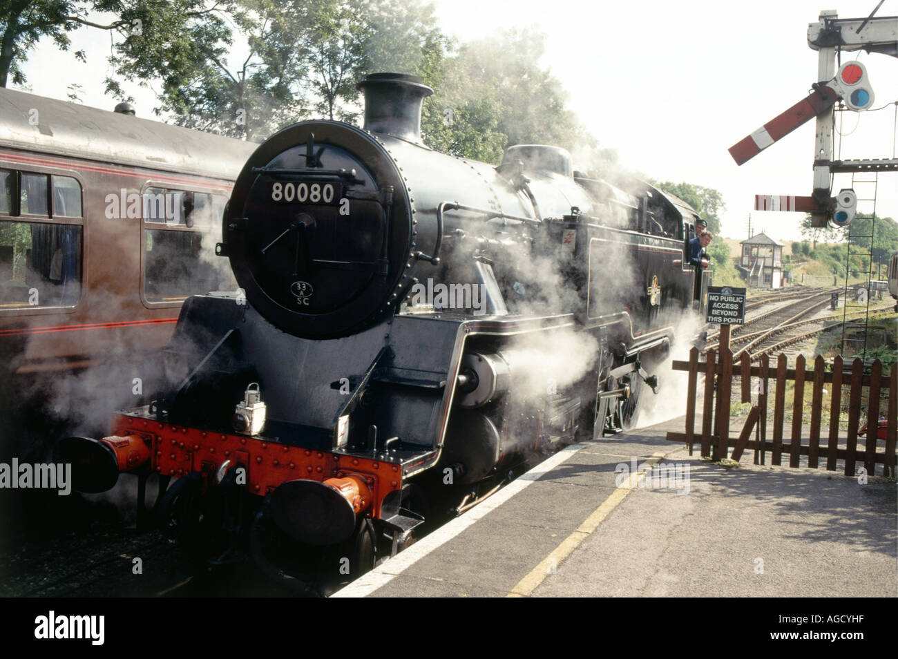 A 1954 steam engine built by British Railways passes a signal at ...