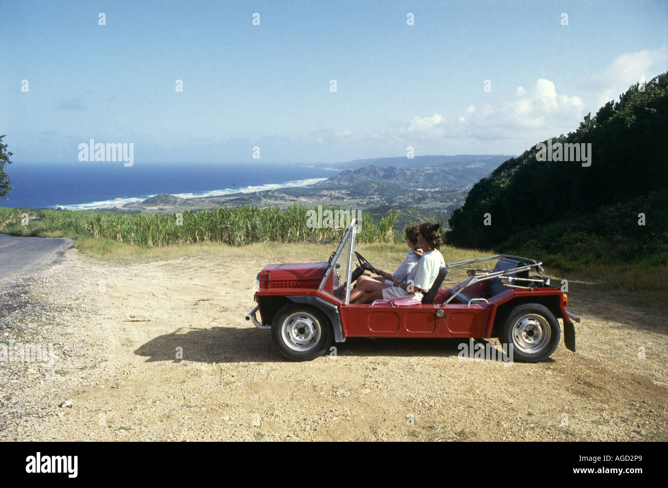 A couple of sightseers in a hired Mini Moke kit car and parked on a ...