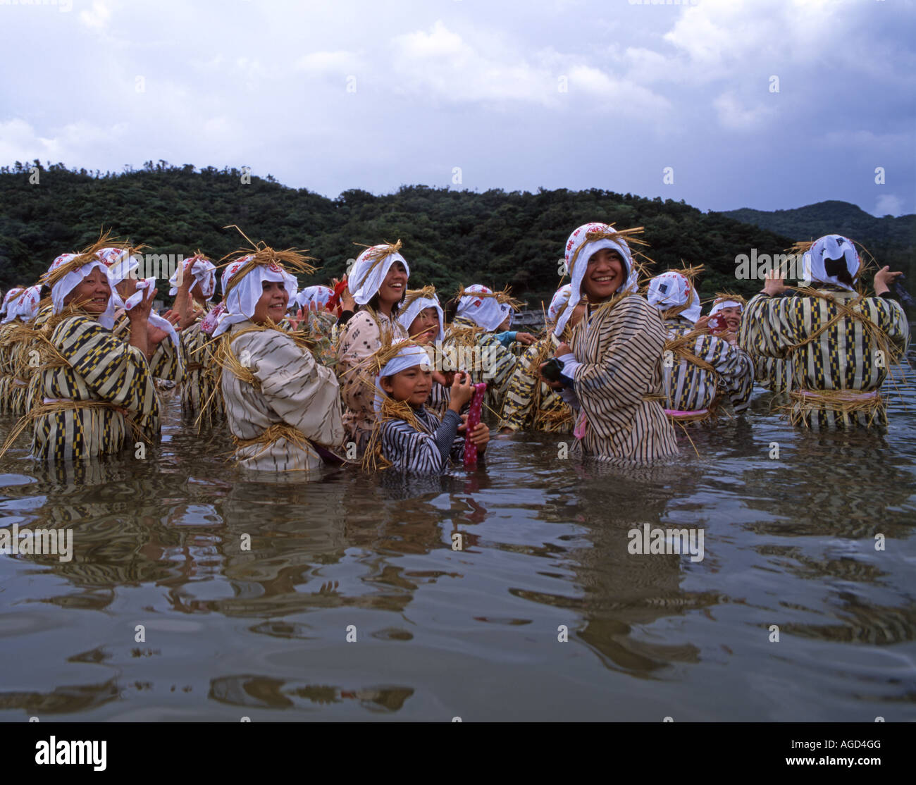 Shioya Ungami festival in Ogimi Village, Okinawa, Japan. Women stand in ...