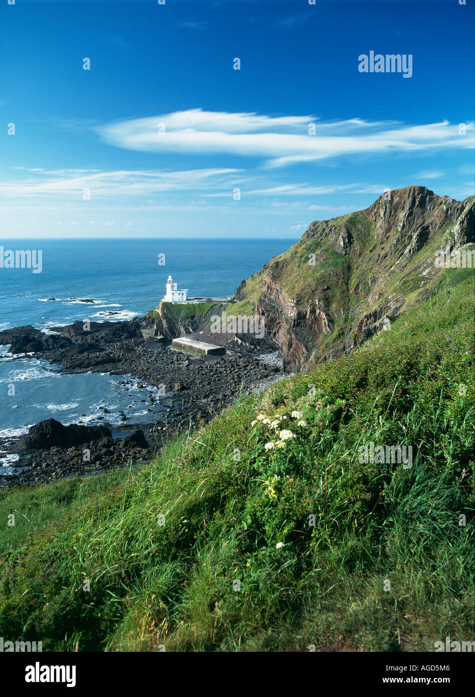 Small white Hartland Point lighthouse on grassy cliffs Stock Photo - Alamy
