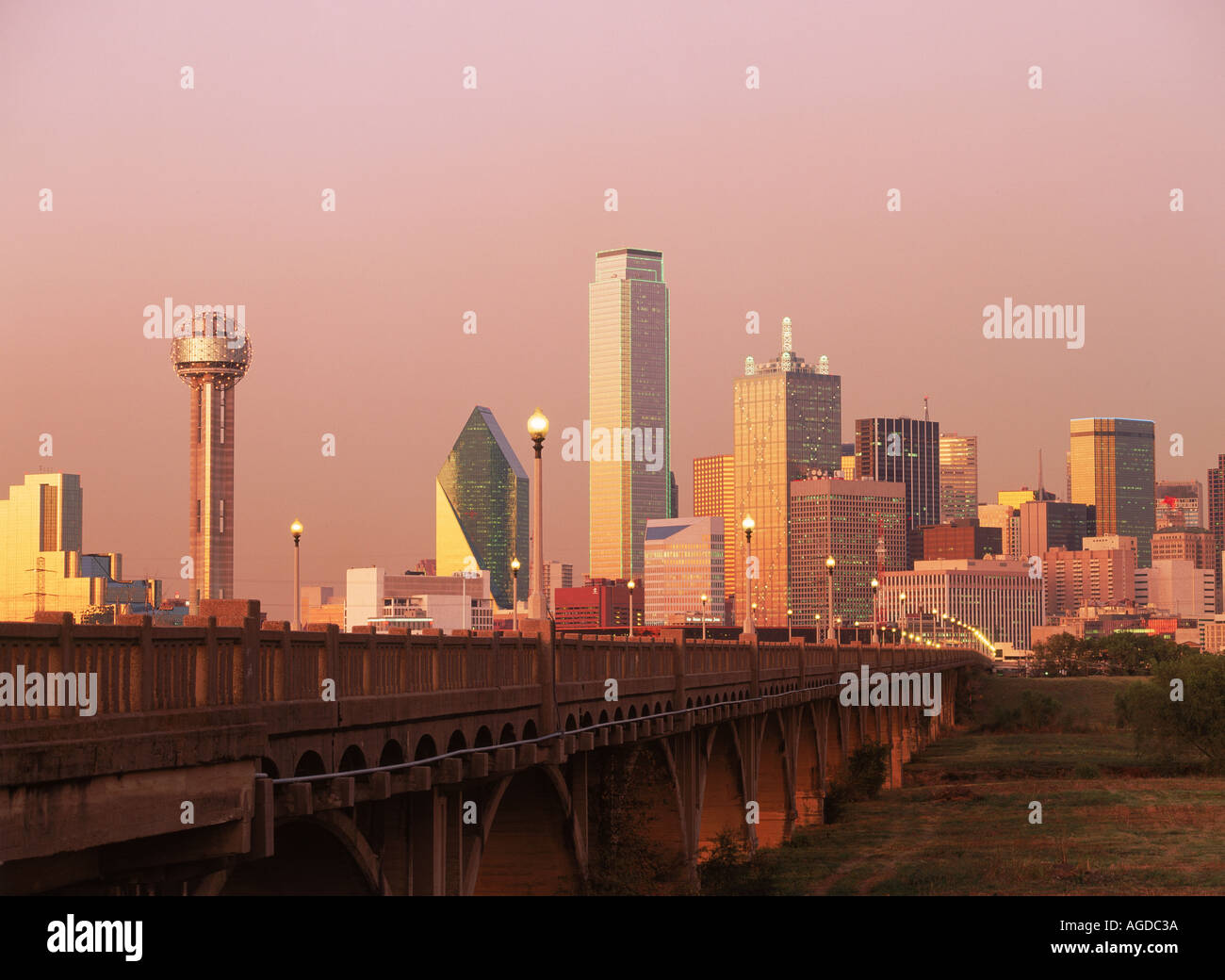 Dallas skyline in sunset light over viaduct with Reunion Tower on left ...