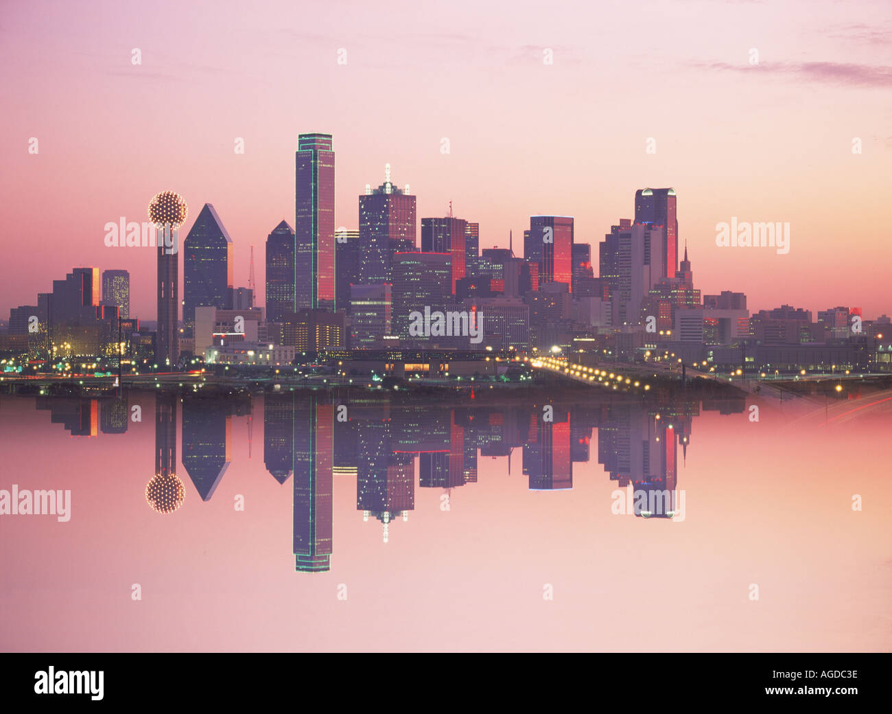 Dallas skyline in warm glow of sunrise light reflecting off glassy ...