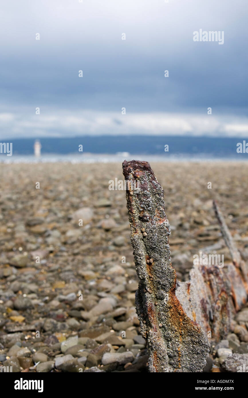 Rusting shipwreck with Whiteford Lighthouse in distance Stock Photo - Alamy