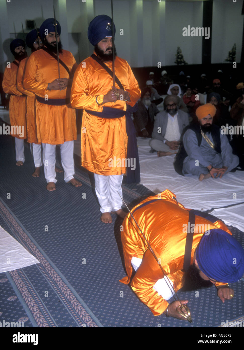 Sikh men representing the ` Five Holy Ones` kneel before the Guru ...