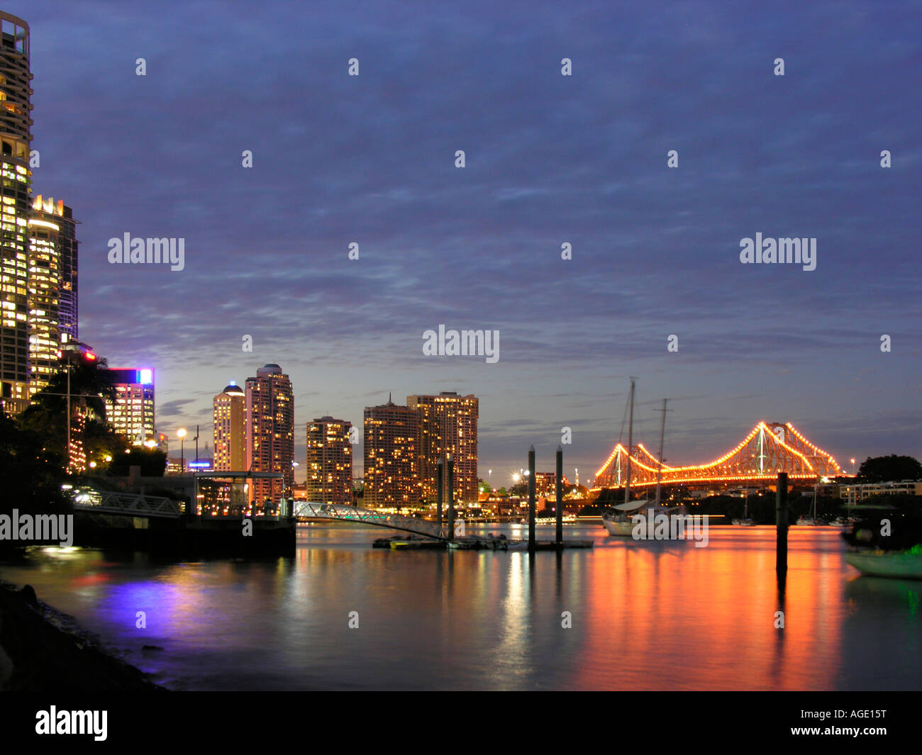 Brisbane city skyline and Story Bridge lights reflecting in calm river ...