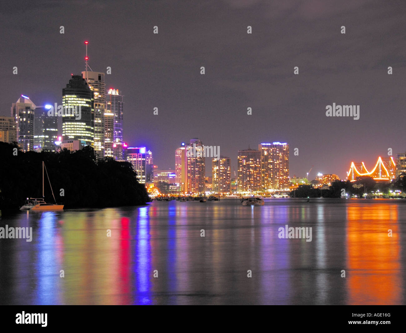 Brisbane city skyline and Story Bridge lights reflecting in calm river ...