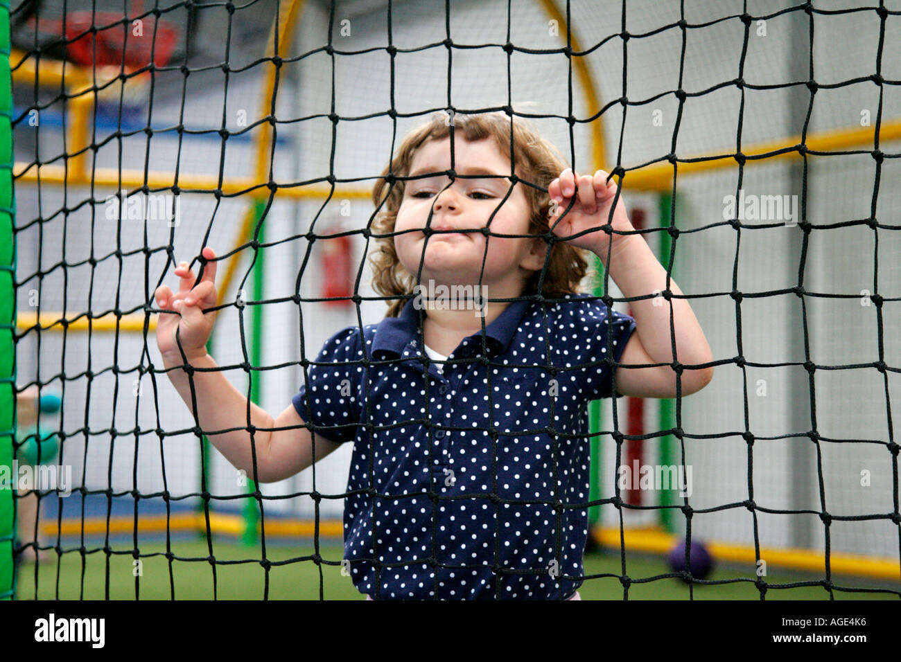 little girl kid kiddy behind a playground net Macclesfield Fun 4 all ...