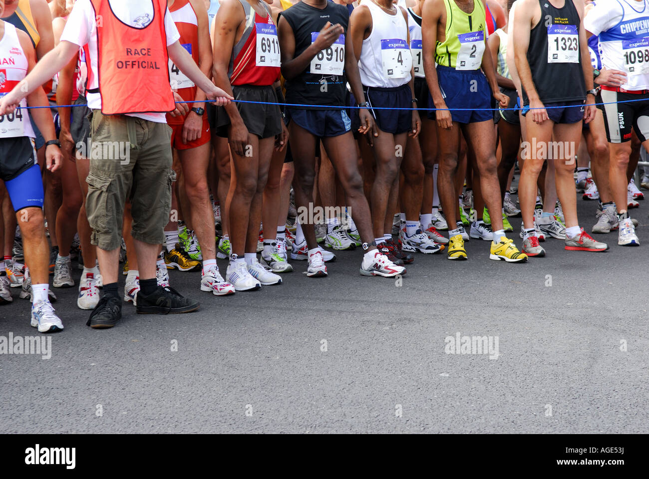 Race official hold back runners Stock Photo - Alamy