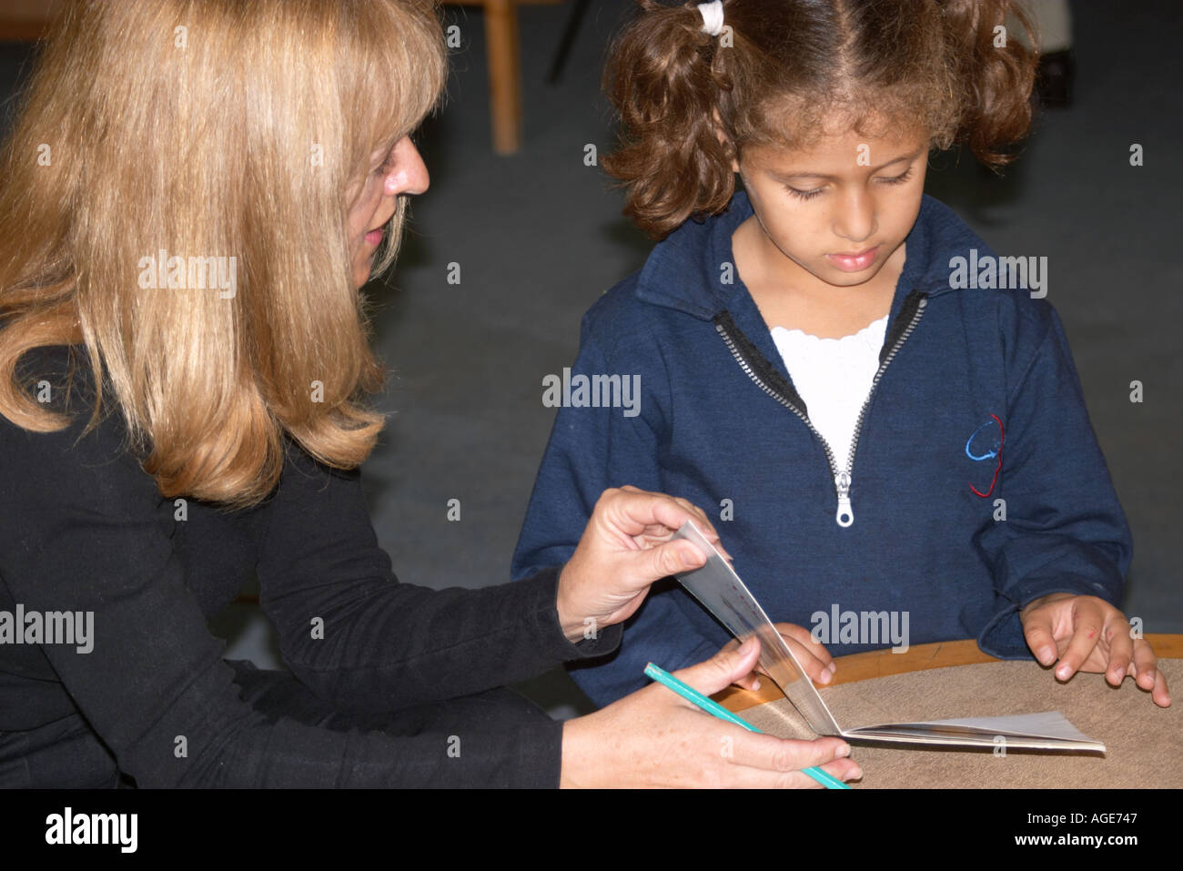 young girl and teacher in school Stock Photo - Alamy