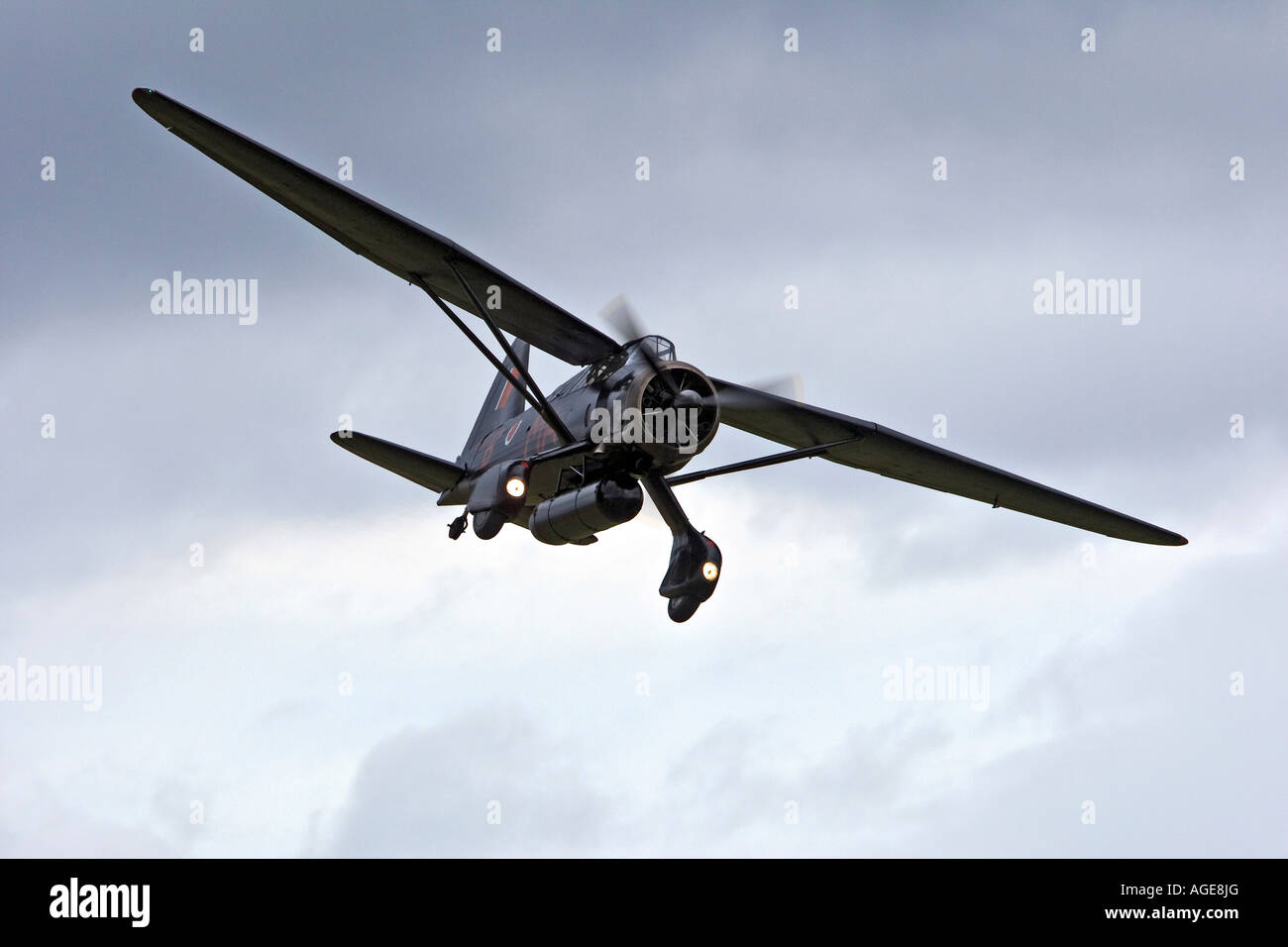 Old plane flying in cloudy sky old warden Stock Photo - Alamy