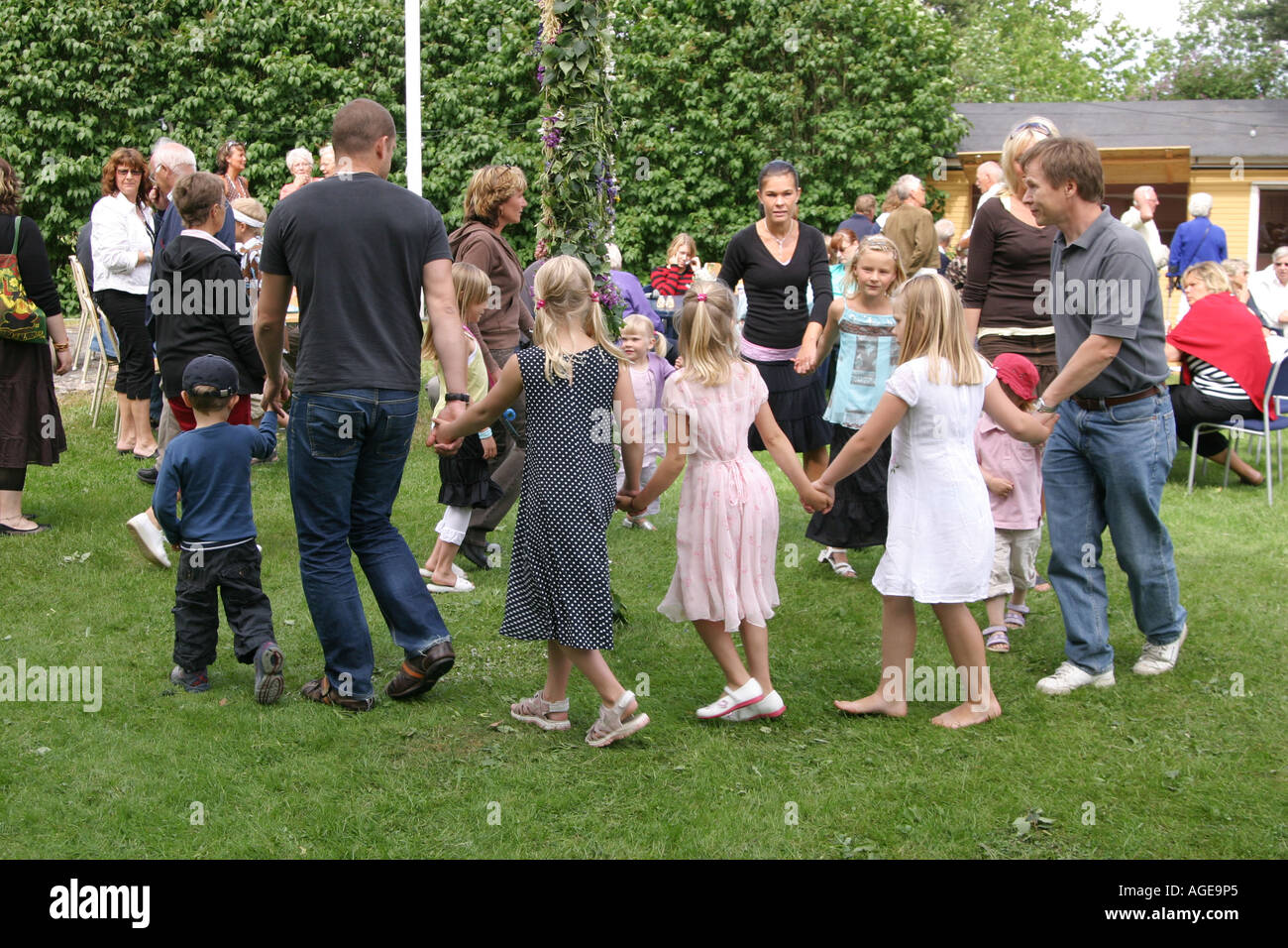Families having fun at midsummer celebration in Sweden. Maypole dancing ...