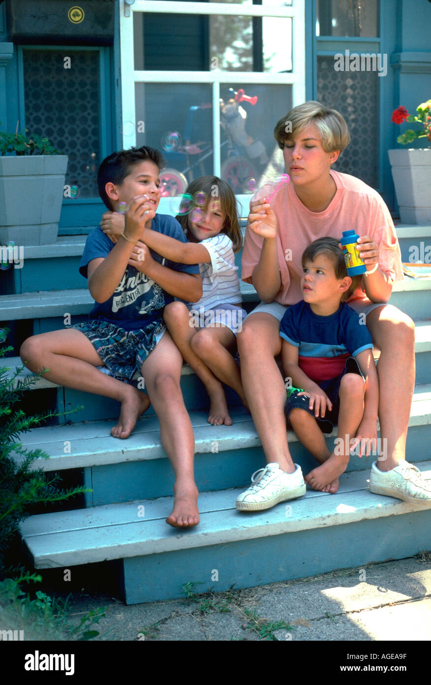 Siblings blowing bubbles with baby sitter ages 18 and 4 thru 7. St Paul ...
