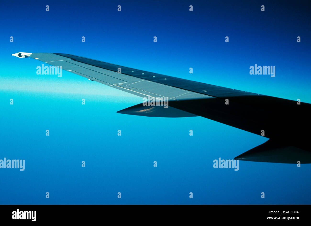 A view on an airplane wing trough the window with light dark sky in ...