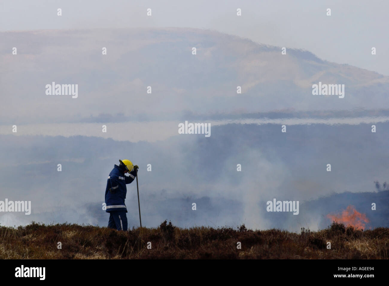 Exhausted fireman firefighter at fire on moorland in the Brecon Beacons ...