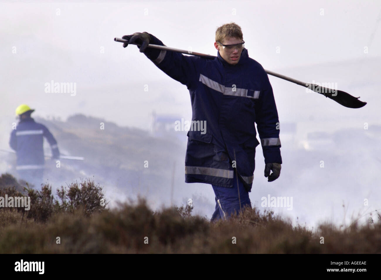 Exhausted fireman firefighter at wildfire on heather moorland in the ...