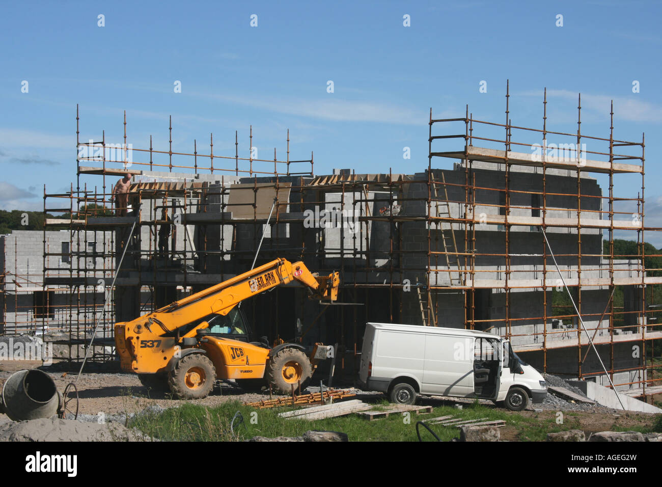 Transit van and construction vehicle on building site outside Cong ...
