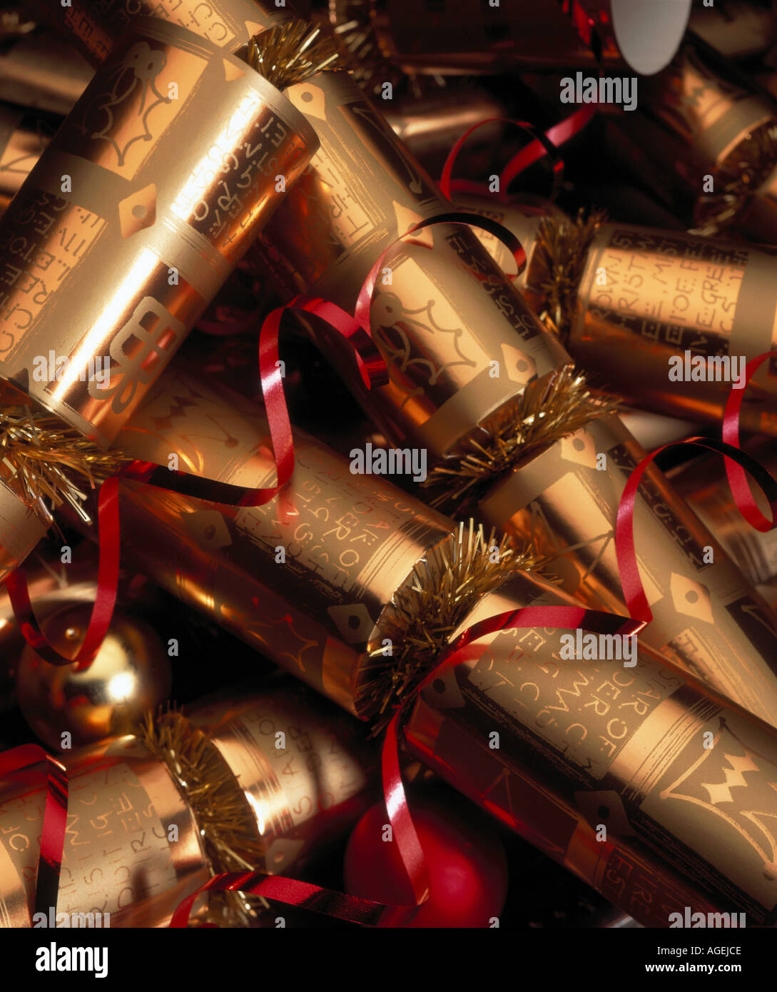 A pile of gold Christmas crackers with red ribbons Stock Photo - Alamy