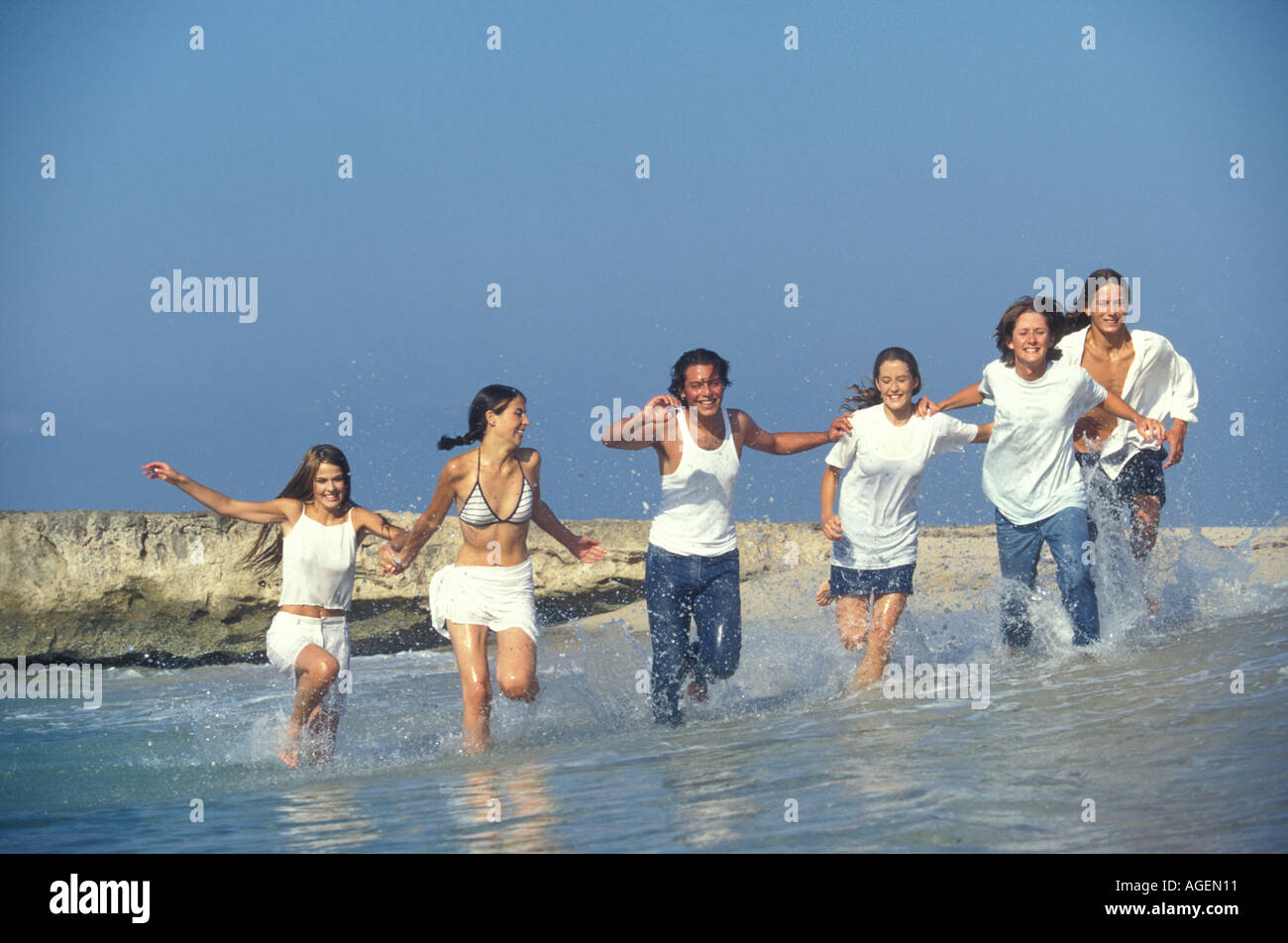 group of young people running through shallow water Stock Photo - Alamy