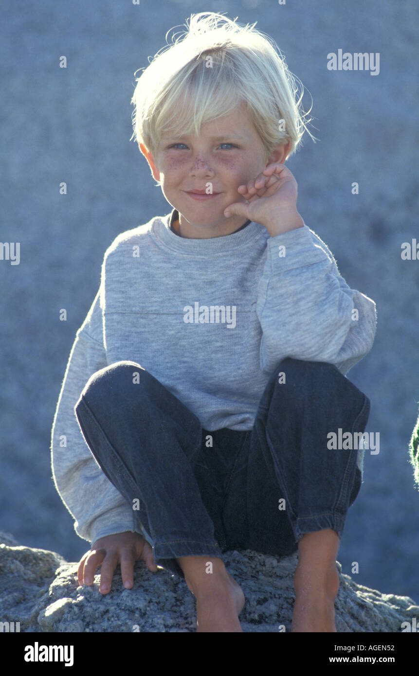 little boy sitting on rock outdoors Stock Photo - Alamy