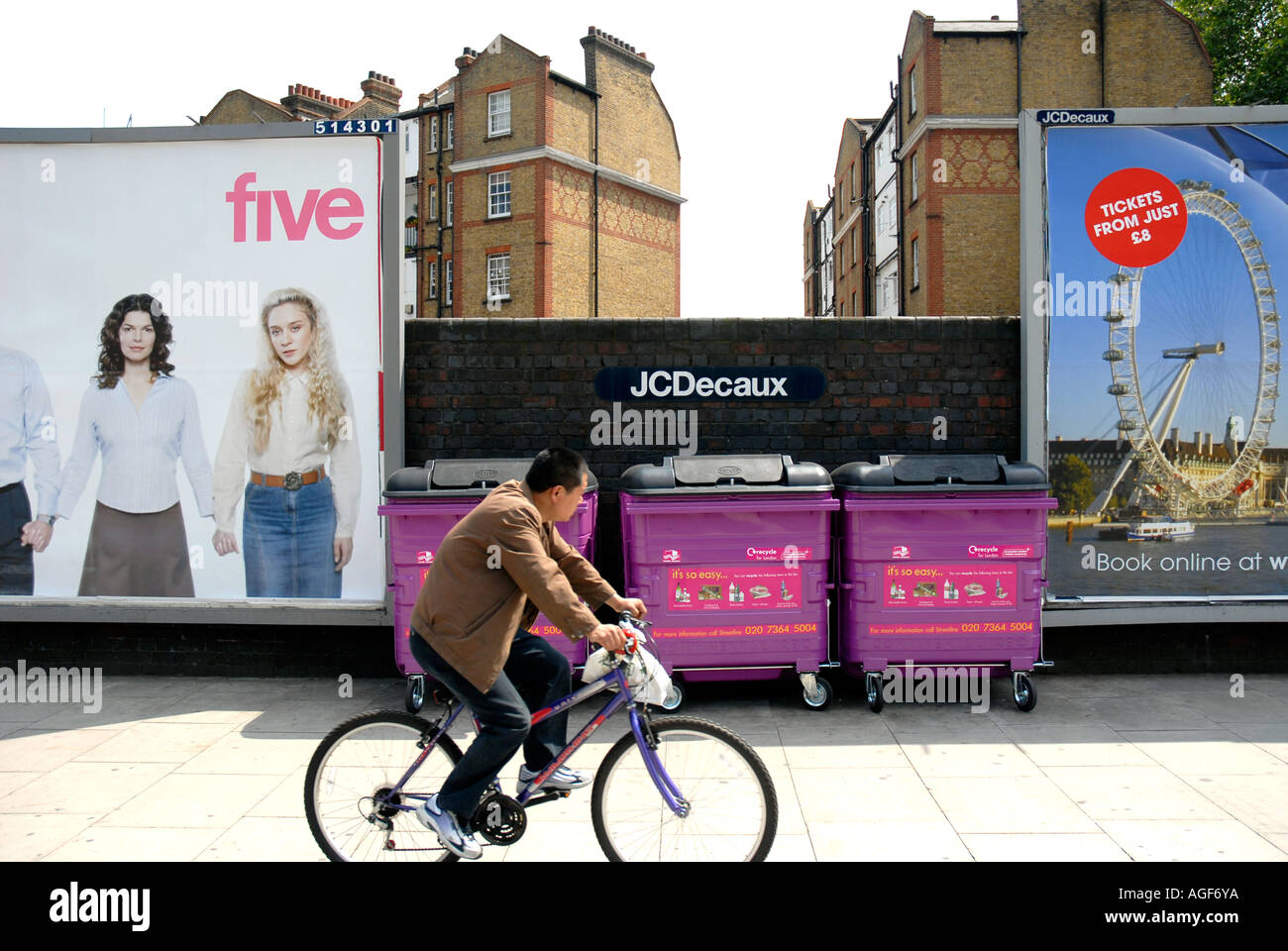 Man cycling past recycle bins in Mile End London Stock Photo - Alamy
