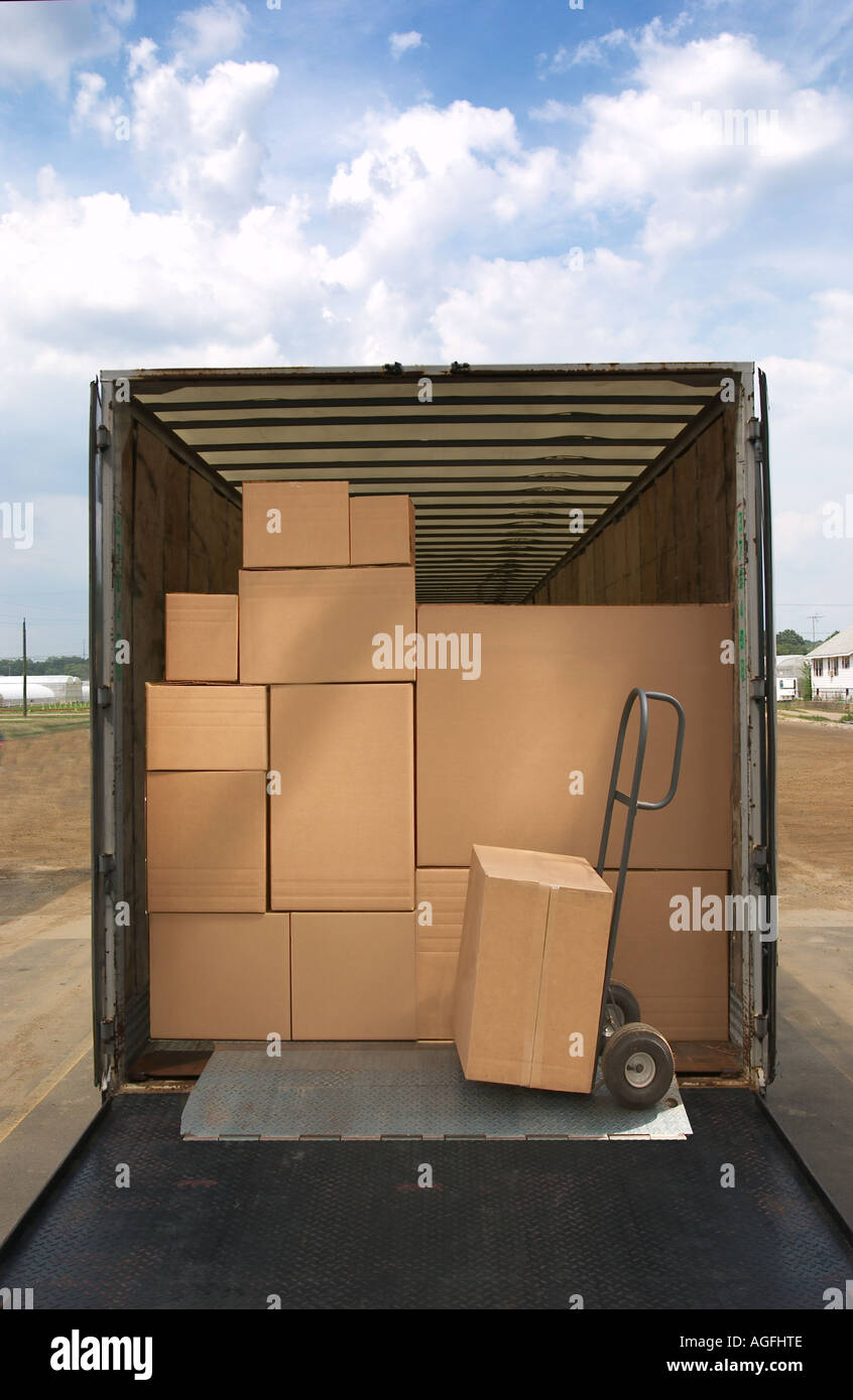 Semi-truck parked on a country road loaded with boxes. Back gate is ...