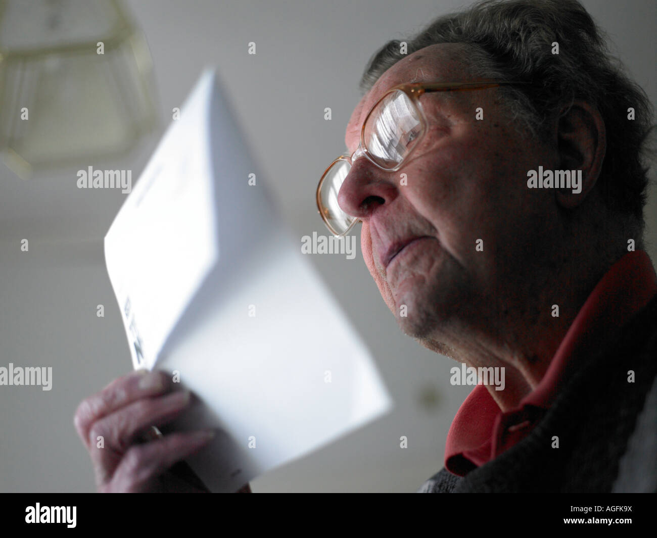 Old man reading bill Stock Photo - Alamy
