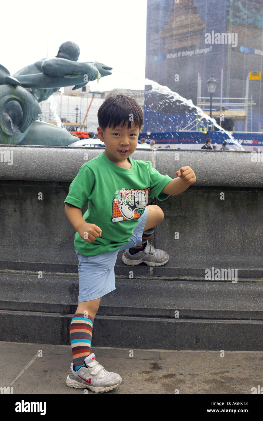 A Chinese boy tourist is posing a comic Shaolin in front of Trafalgar ...