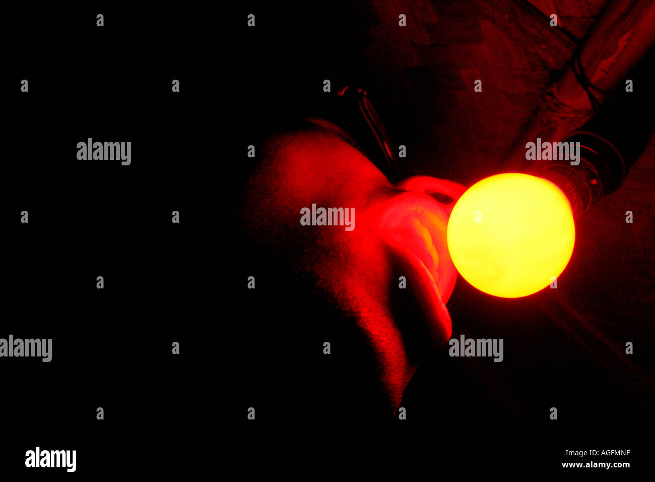 Man trying to eat a glowing bulb Stock Photo - Alamy