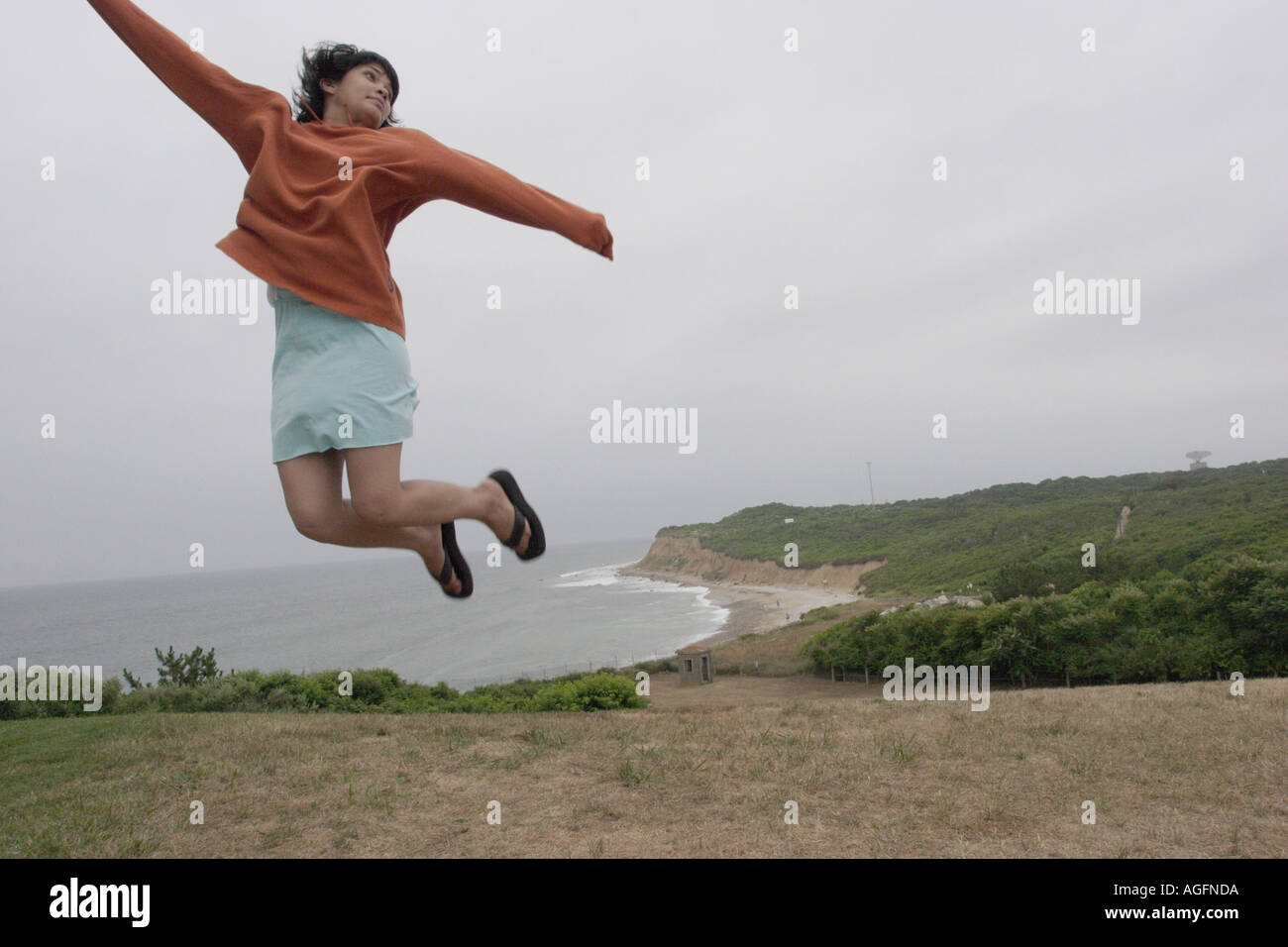 woman jumping by lighthouse fun day off recreation joy jumping for joy ...