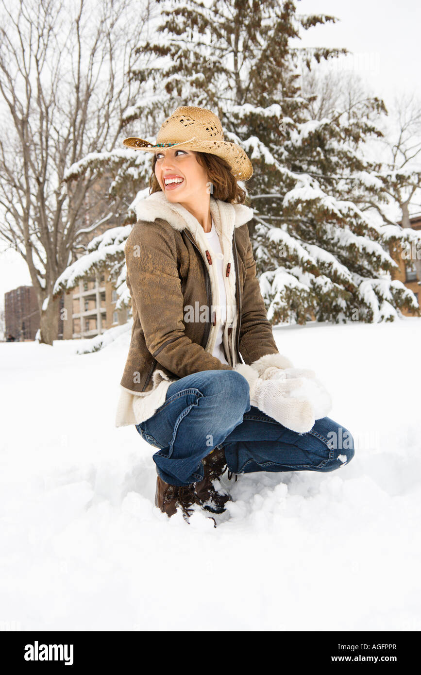 Caucasian young adult female looking over shoulder while kneeling in ...