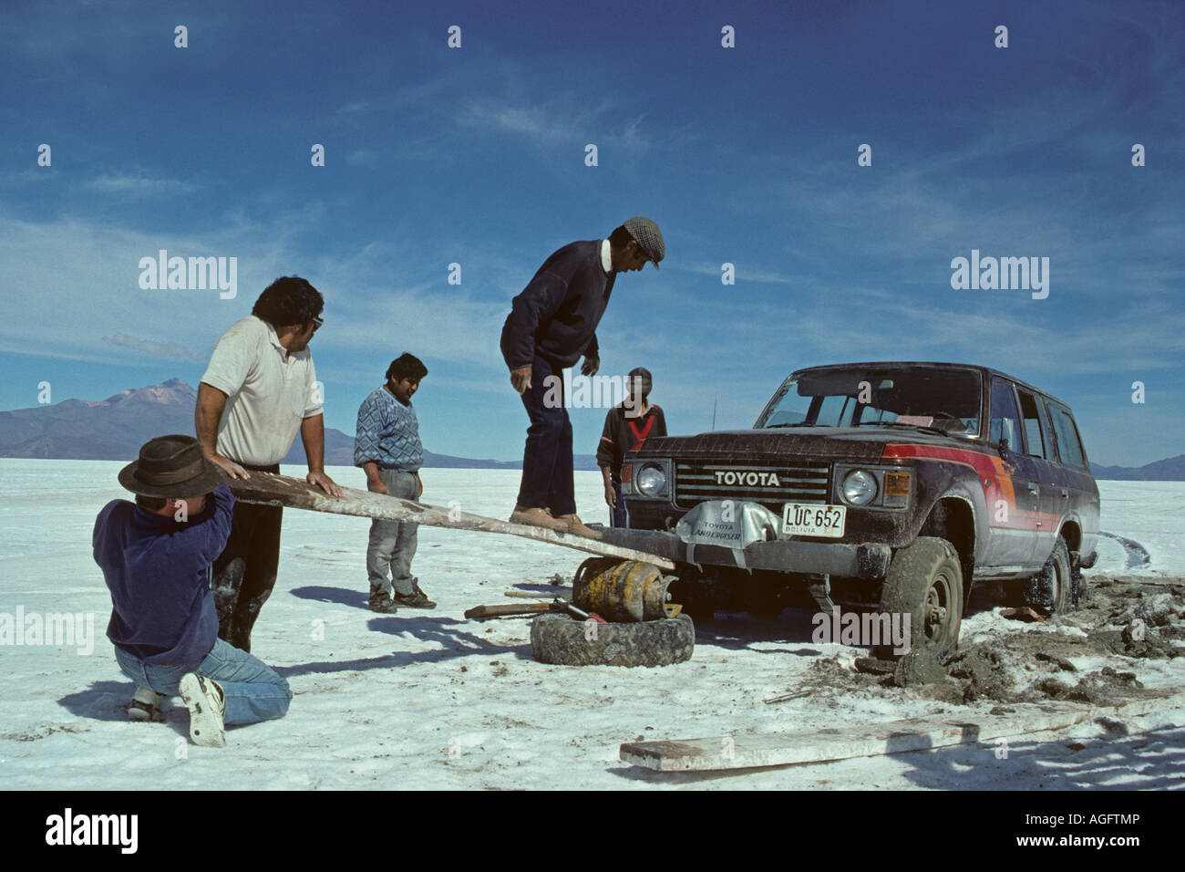 Bolivia, Uyuni, People trying to get car out of mud in Uyuni salt lake ...