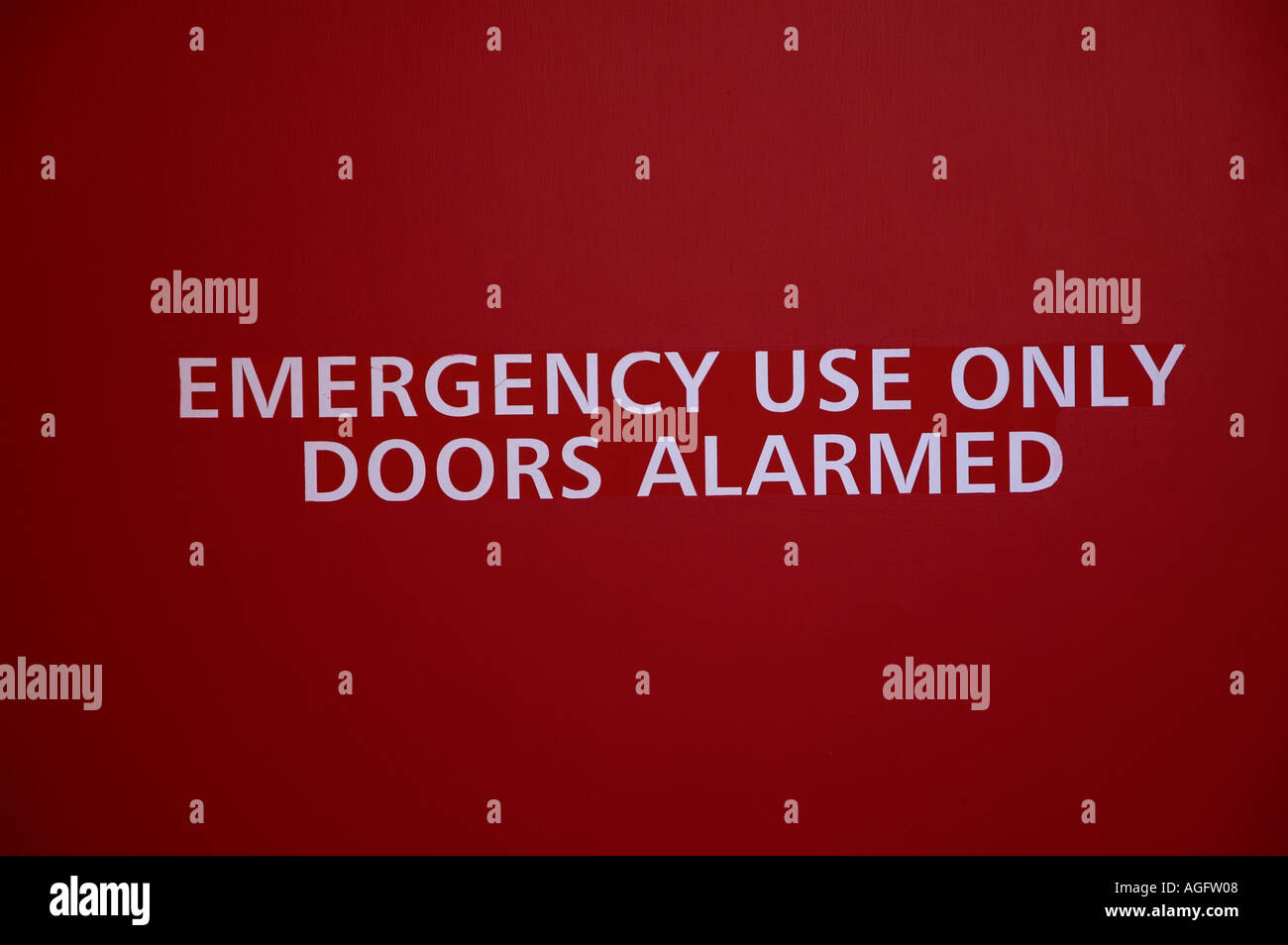 Emergency exit sign in red door Stock Photo - Alamy