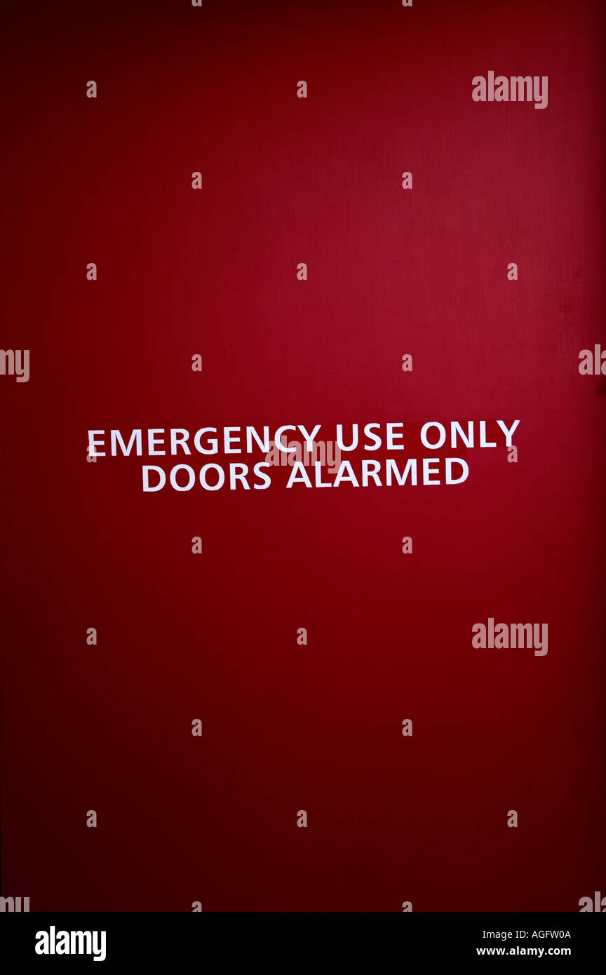 Emergency exit sign in red door Stock Photo - Alamy