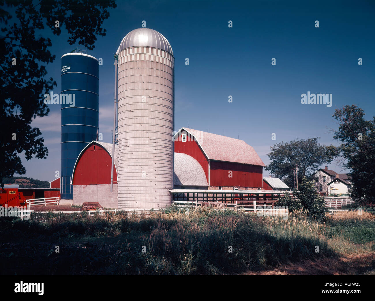 Wisconsin dairy farm with typical red barns and towering storage silos ...