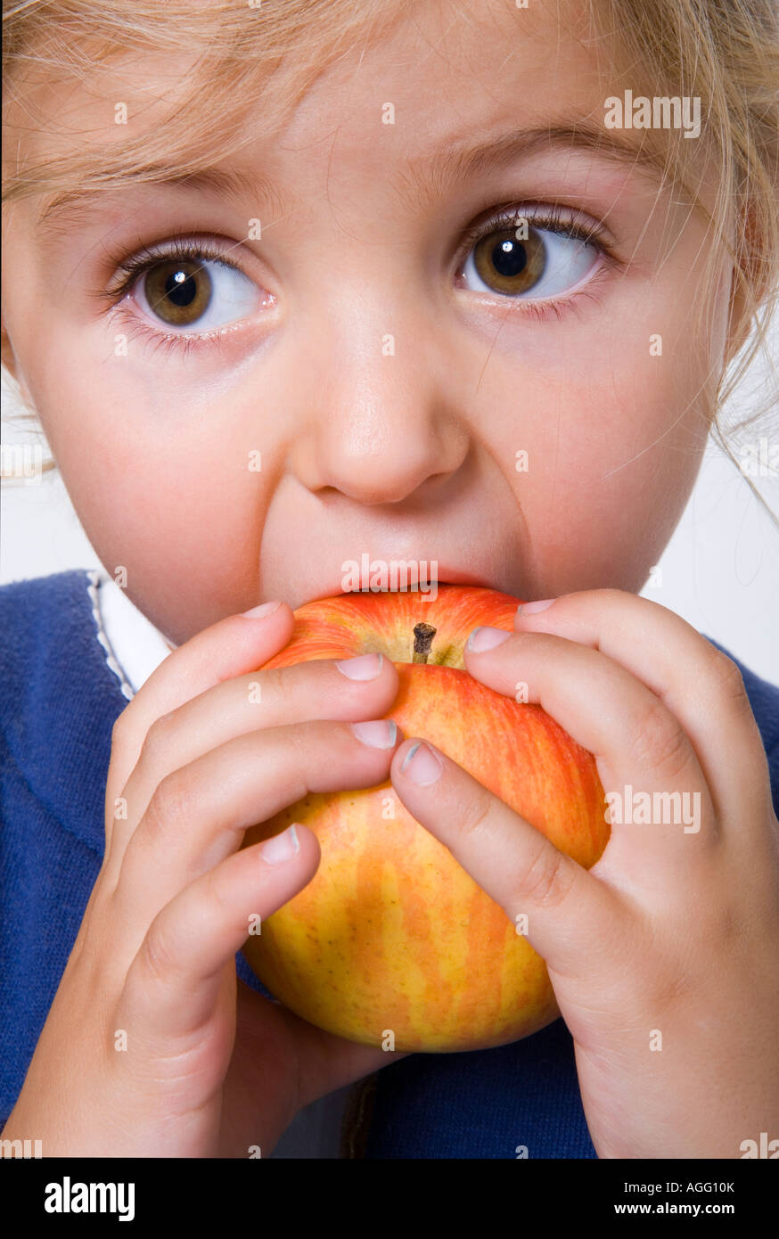 Little girl bites an apple Stock Photo - Alamy