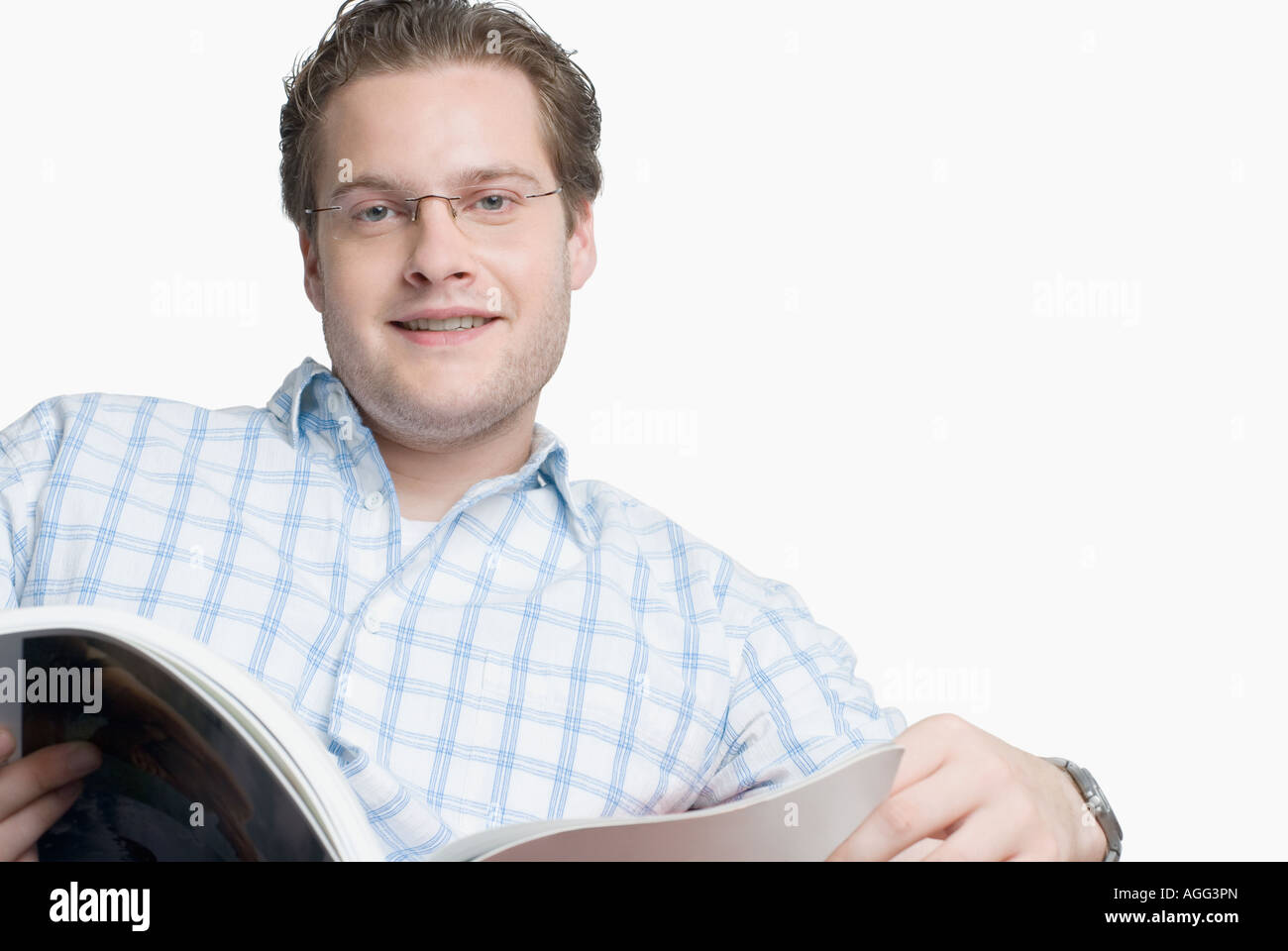 Portrait of a young man holding a magazine and smiling Stock Photo - Alamy