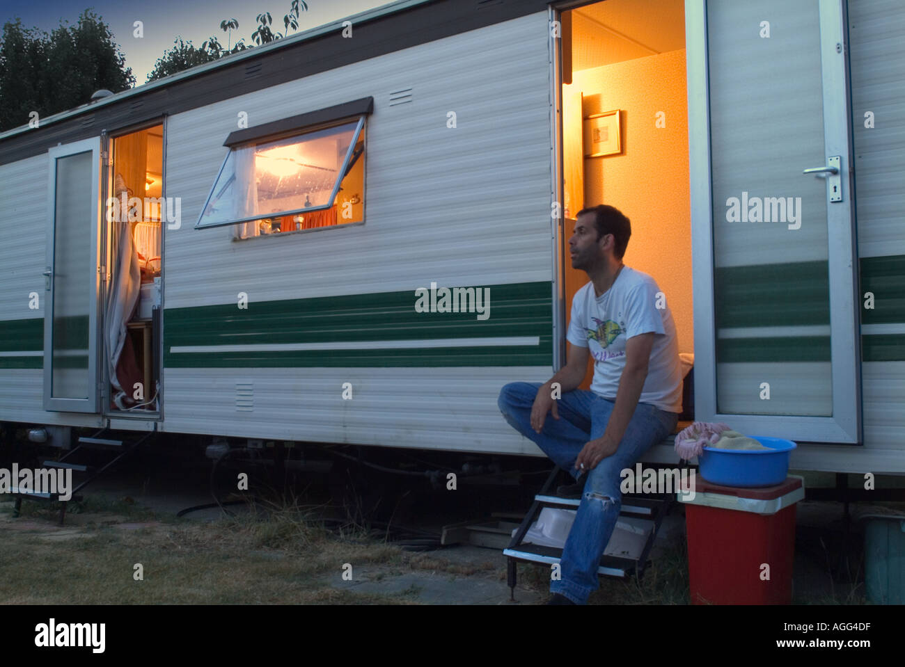 Man wearing jeans model released sitting in doorway of trailer mobile ...